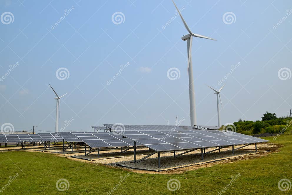 View of an Array of Electricity Producing Solar Panels with Wind Farm ...