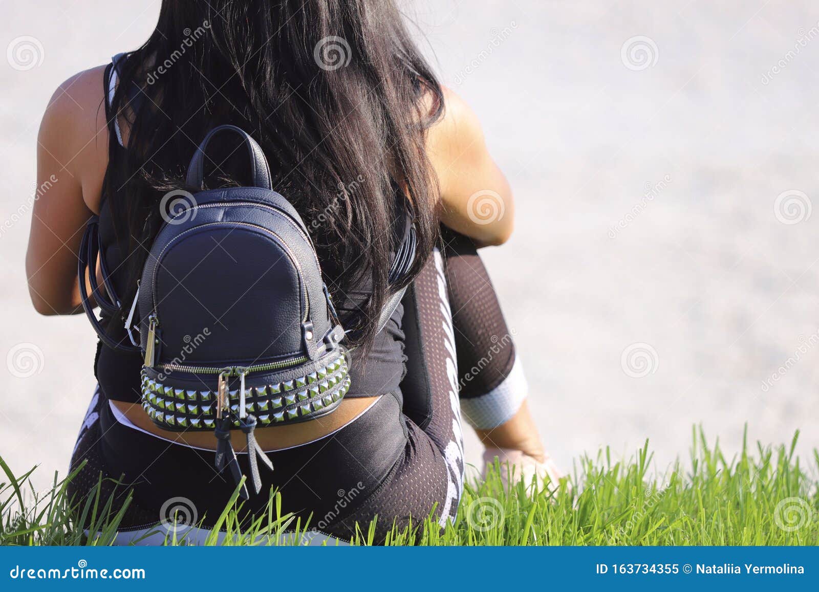 View from the Back of a Girl with a Backpack Sitting on the Grass ...