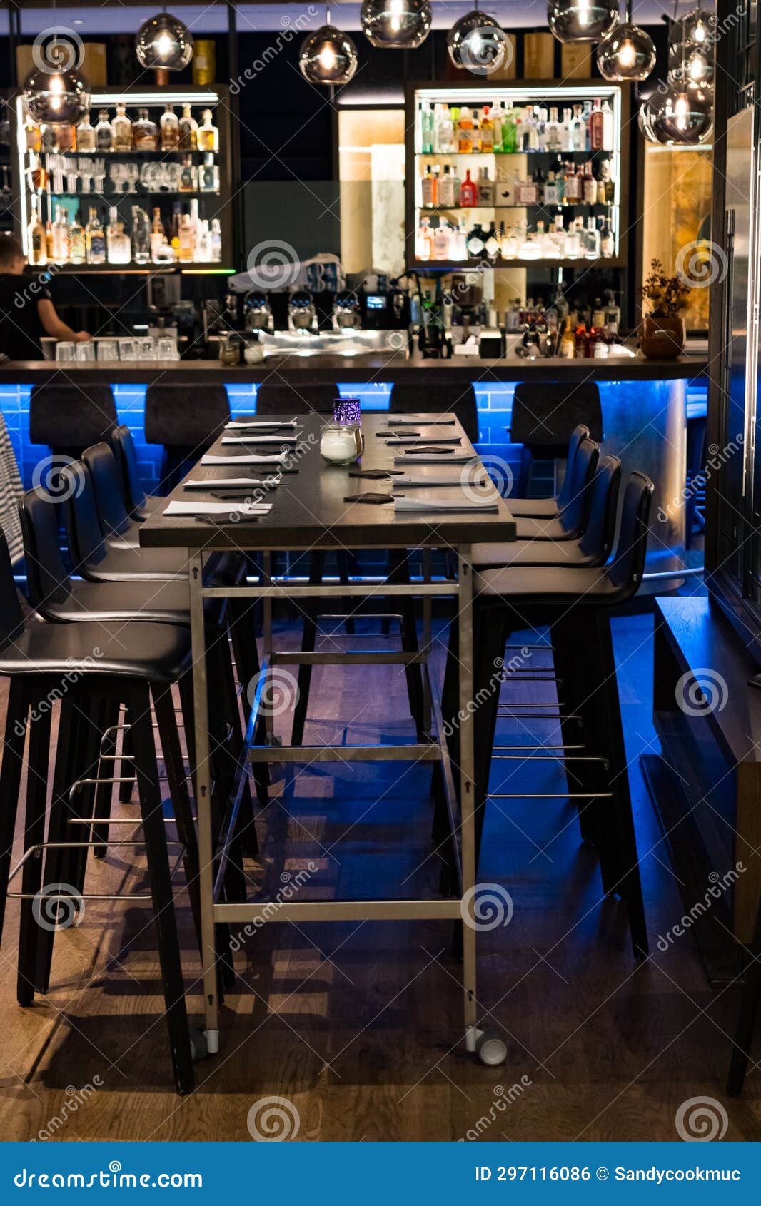 View of a Bar: Blue Lights, Bar Table and Bar Stools, Counter, Drinks ...