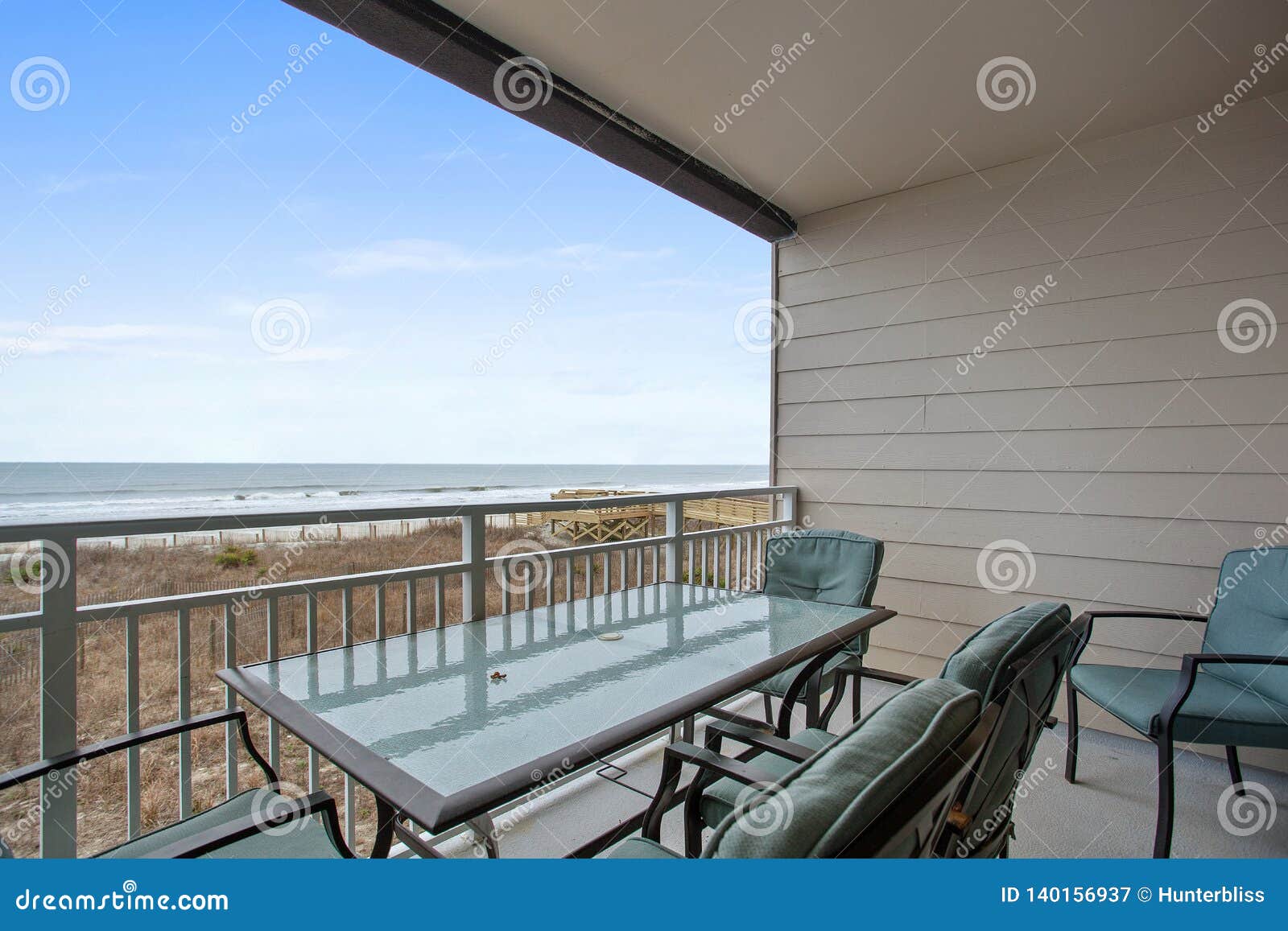 View of Beach from Apartment Balcony Empty with Table and Armchairs ...