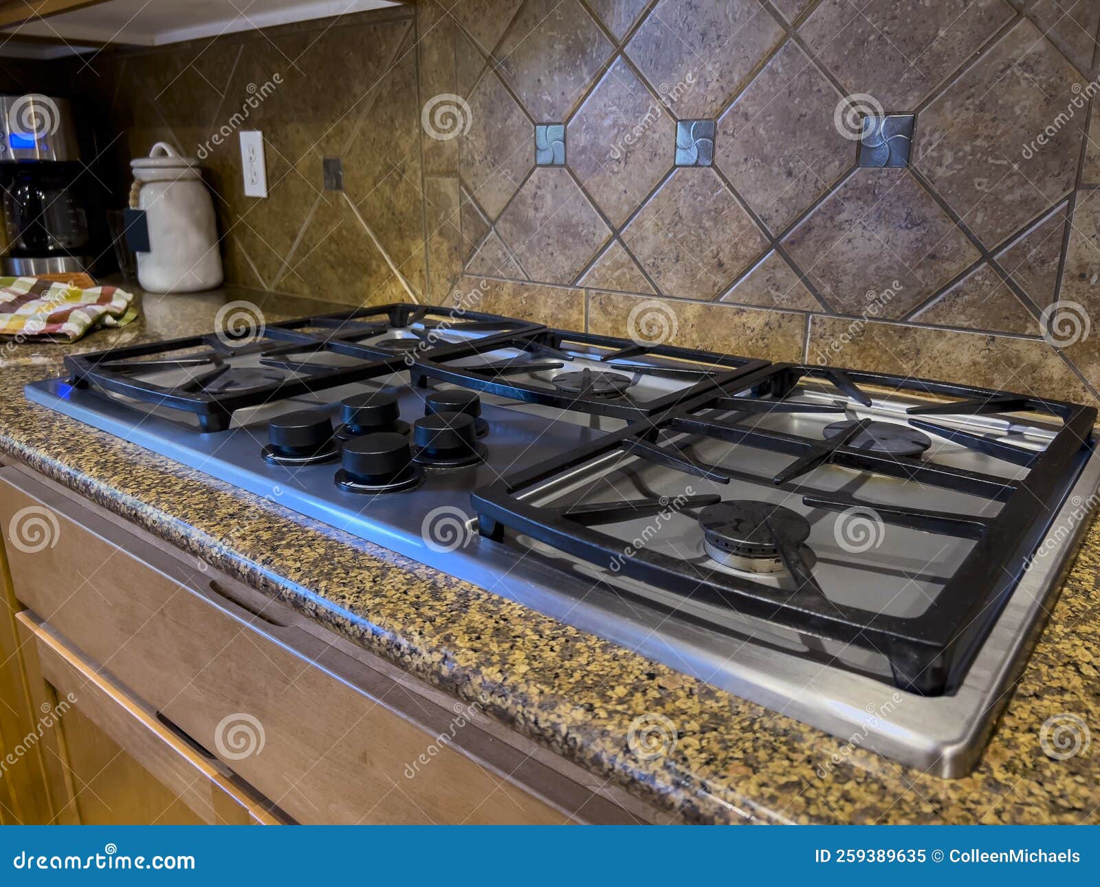 View of a Beautiful Gas Stove Top with Black Knobs Against a Square ...