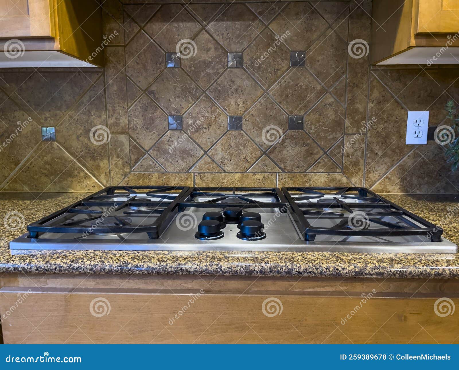 View of a Beautiful Gas Stove Top with Black Knobs Against a Square ...