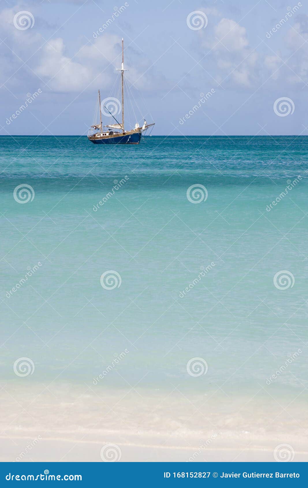 View of Beautiful Tropical Beach with a Sailboat in the Background ...