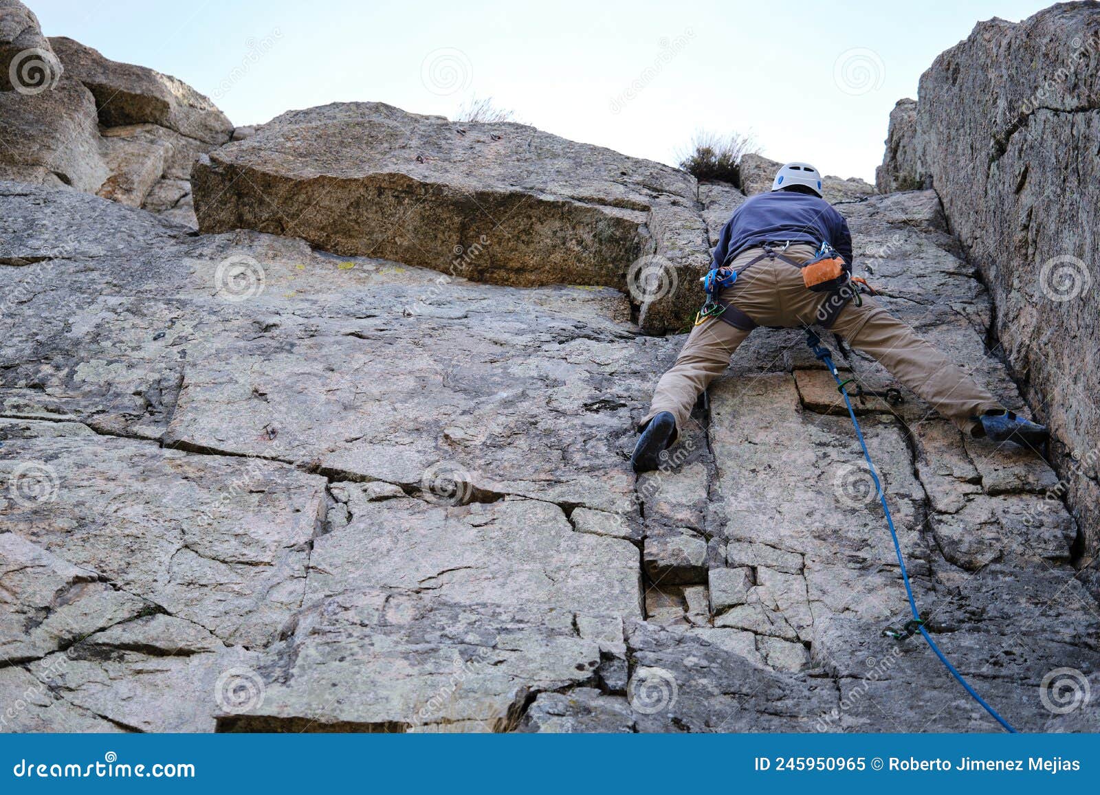 View from Below of a Mature Climber Climbing Up a Cliff Stock Image ...
