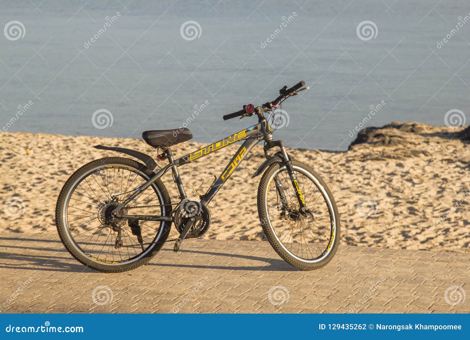 View of the Bicycle Standing on the Beach with the Sea in the Ba ...