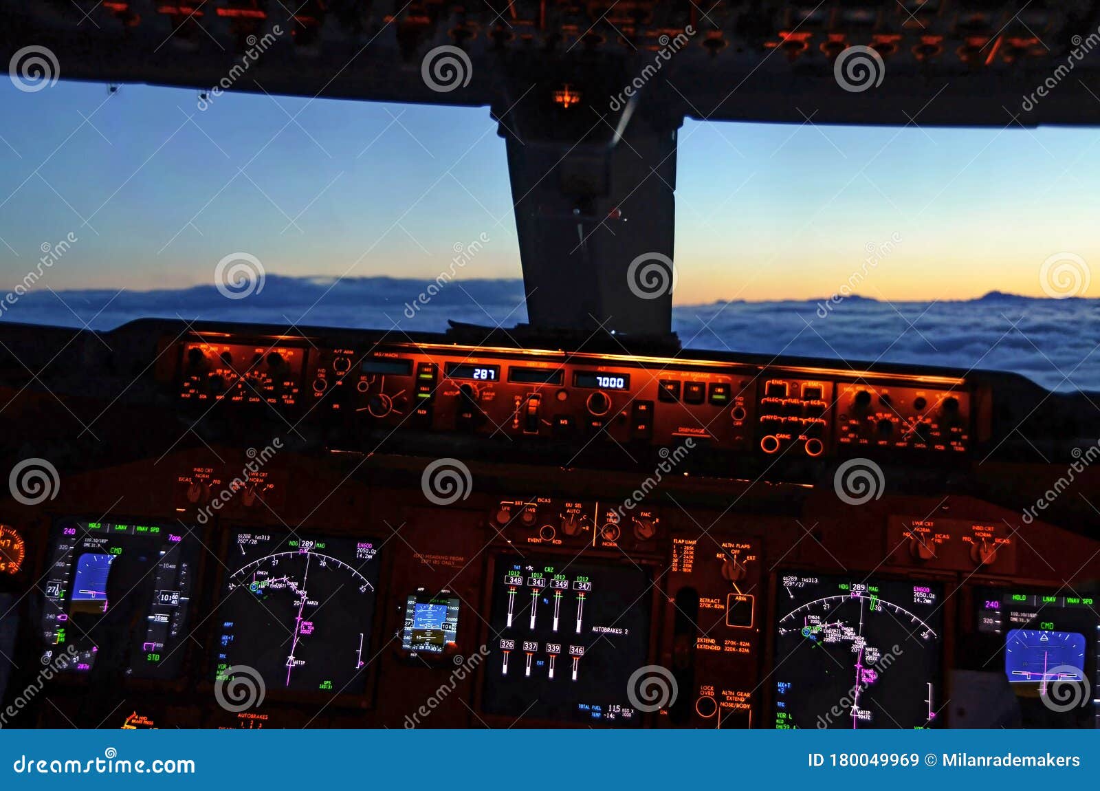 View of the Cockpit of an Airplane with Sunset Flying Above the Clouds ...