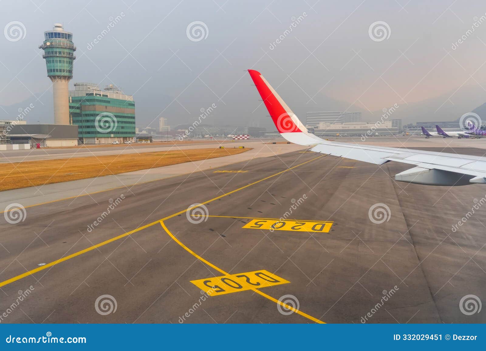 View of the Control Tower and Passenger Terminal with an Airplane Wing ...