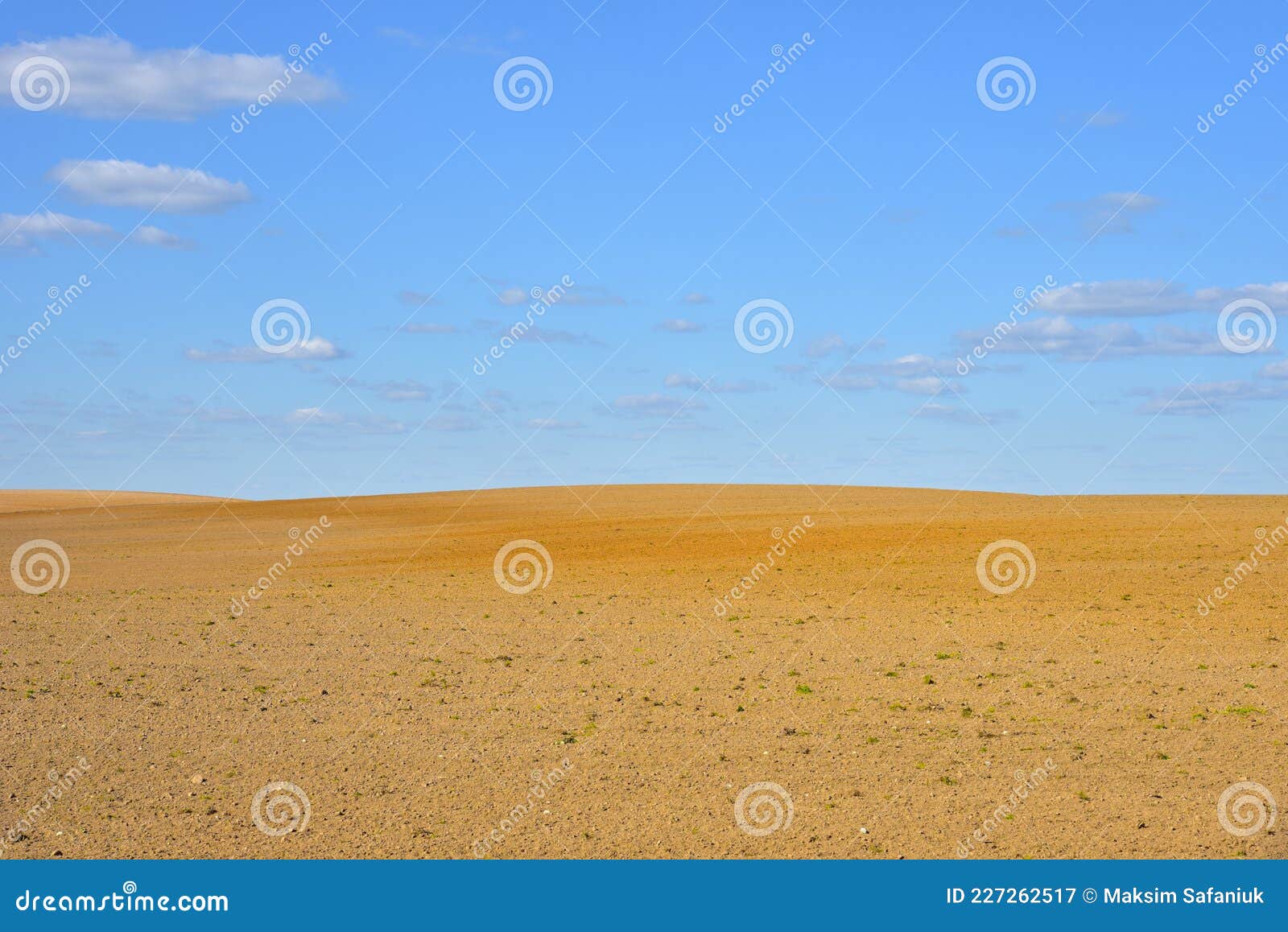 View of a Deserted Sand Field Against a Blue Sky with Clouds Stock ...