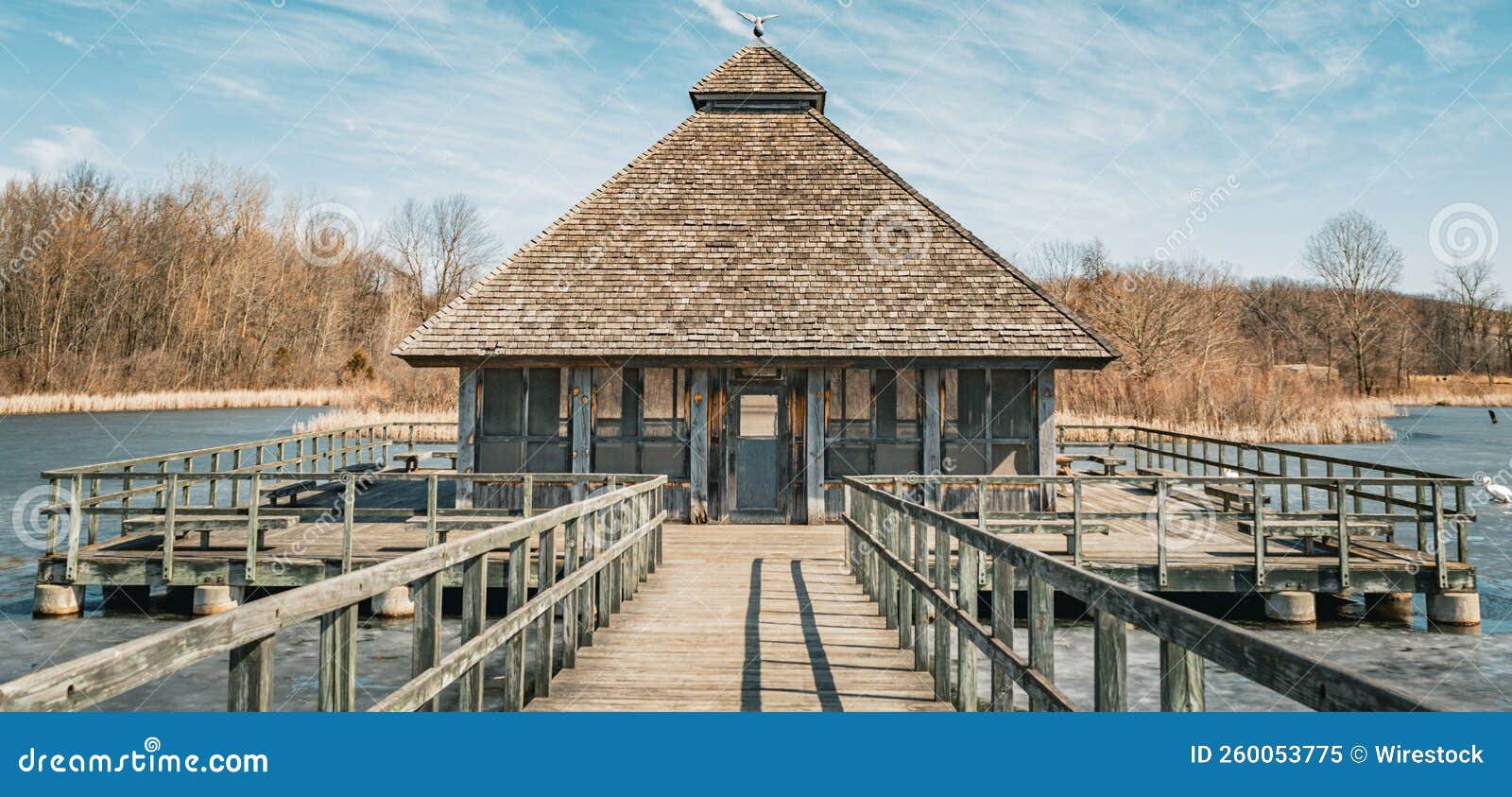 View of Dock with Building Surrounded by Water in Background of Trees ...