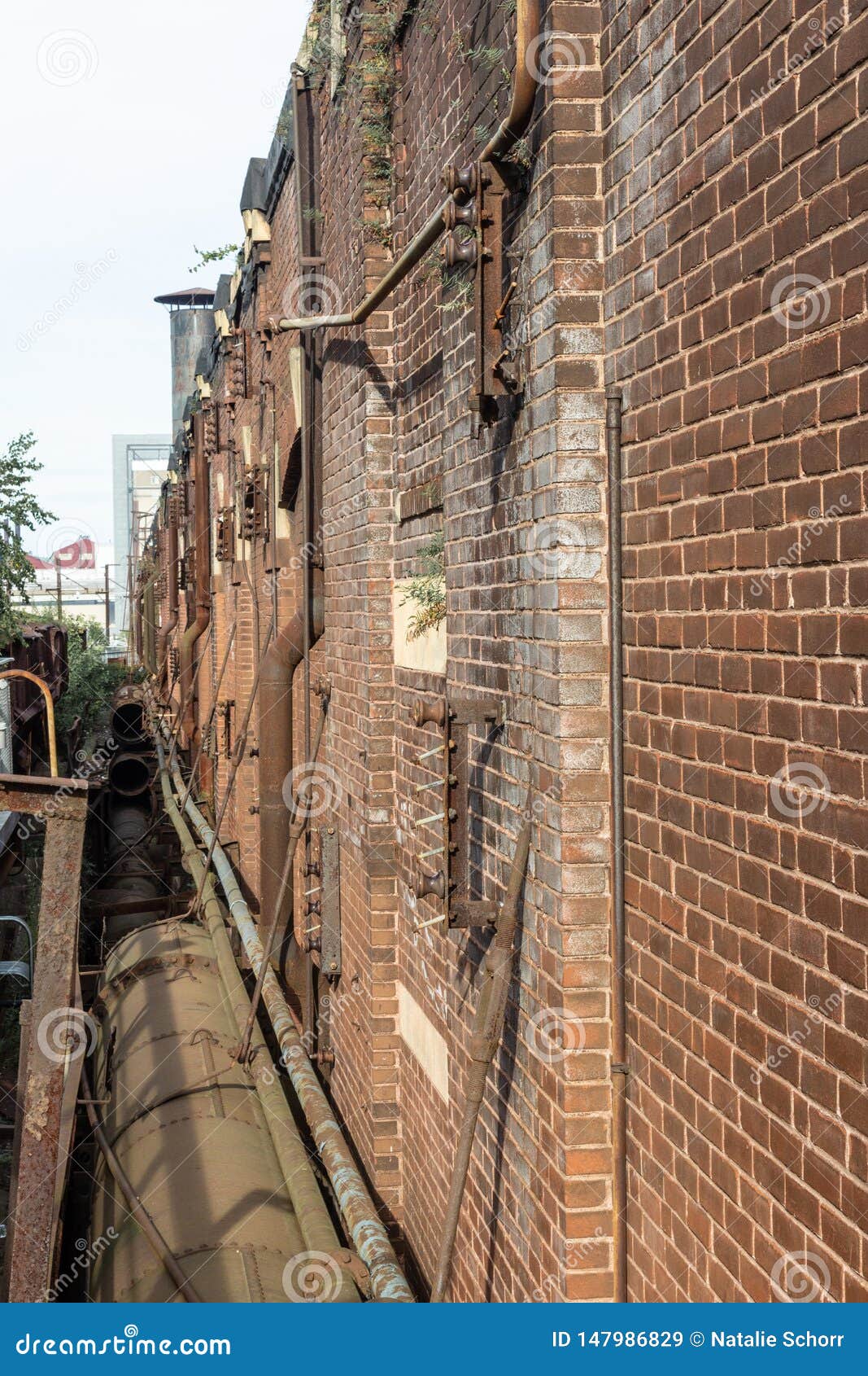 View Down the Face of a Long Industrial Building with Pipes ...