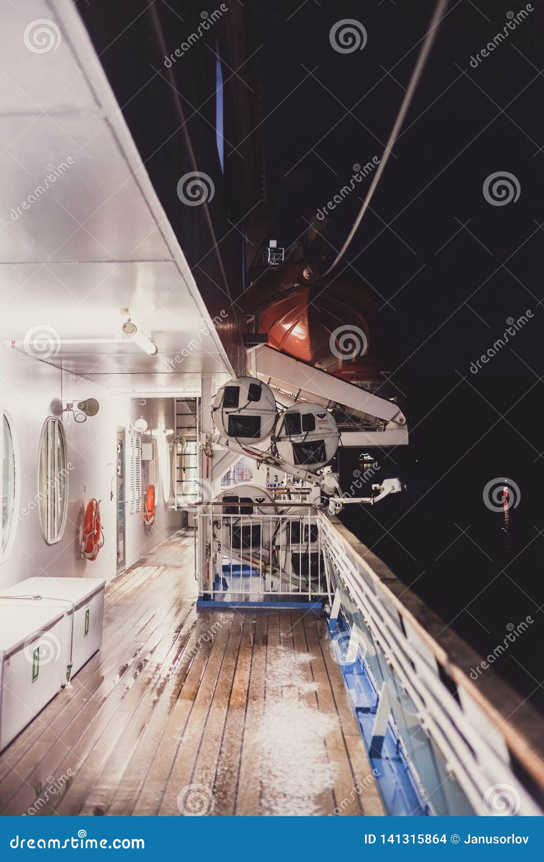 View of the Empty Ship Deck at Night with Life Boats and a Lighthouse ...