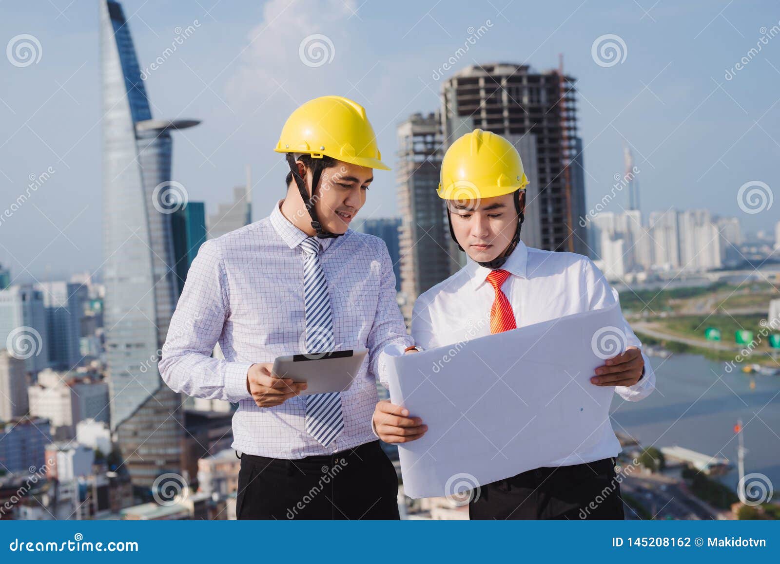 View of a Engineer and Worker Watching Blueprint on Construction Site ...