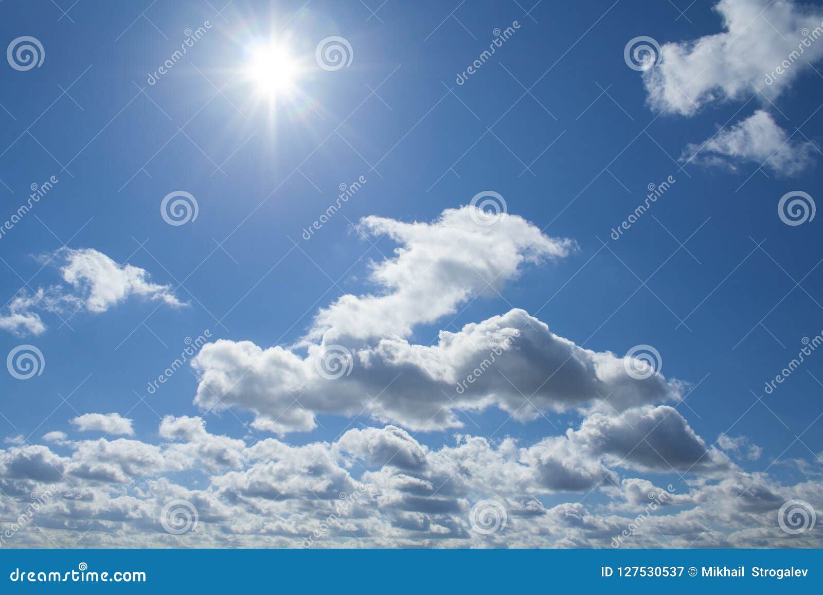 View of a Fluffy Clouds and Midday Sun in Deep Blue Sky Stock Image ...