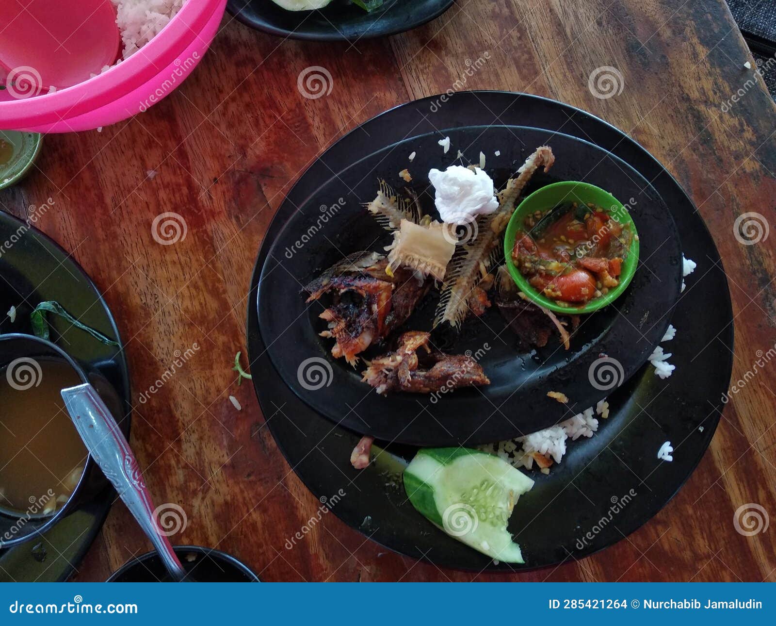 View of a Messy Table with Chicken Bones and Fish Bones on a Black ...