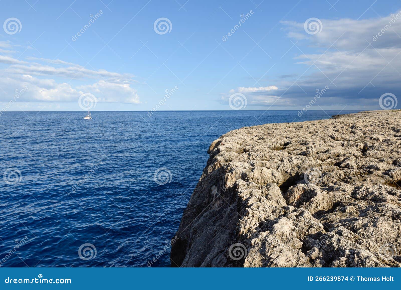 View Over the Ocean from a Cliff As a Boat Sails in the Distance Stock ...
