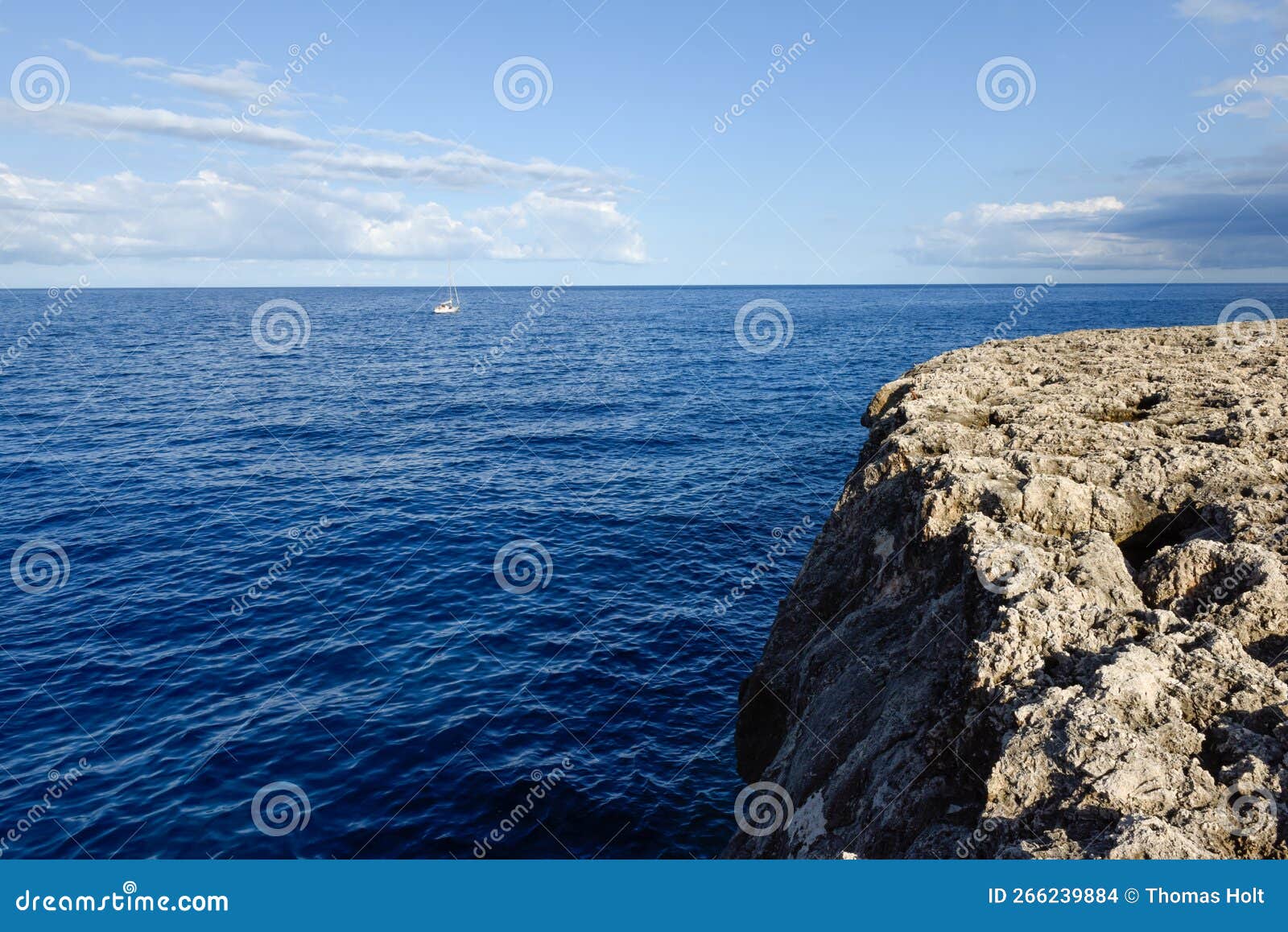 View Over the Ocean from a Cliff As a Boat Sails in the Distance Stock ...