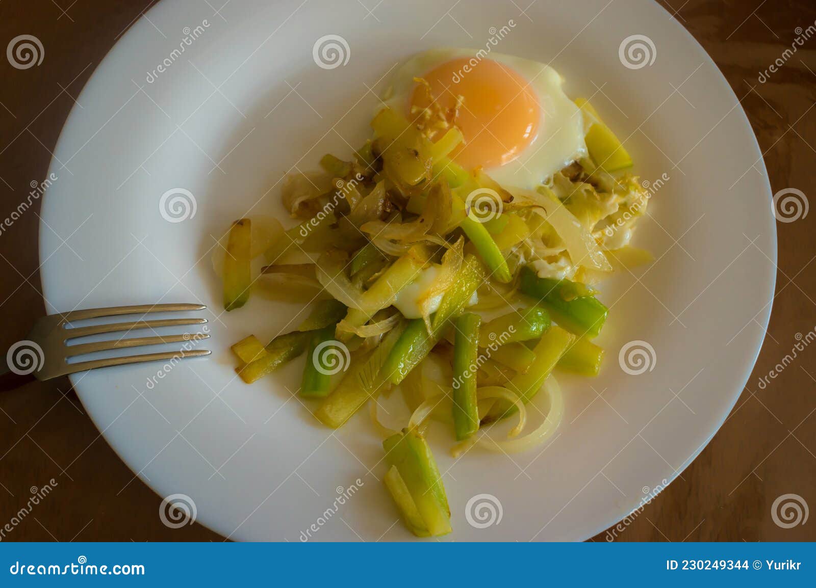 View on Plate with Egg Fried with Slices of Onions and Vegetable Marrow ...
