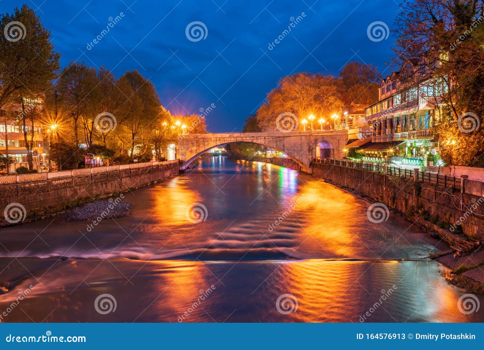 View of the Stone Bridge Over the River at Night with with Rays of ...