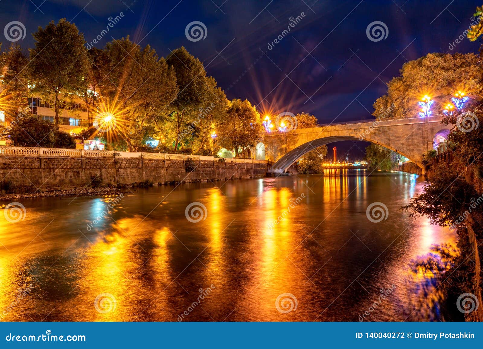 View of the Stone Bridge Over the River at Night with with Rays of ...