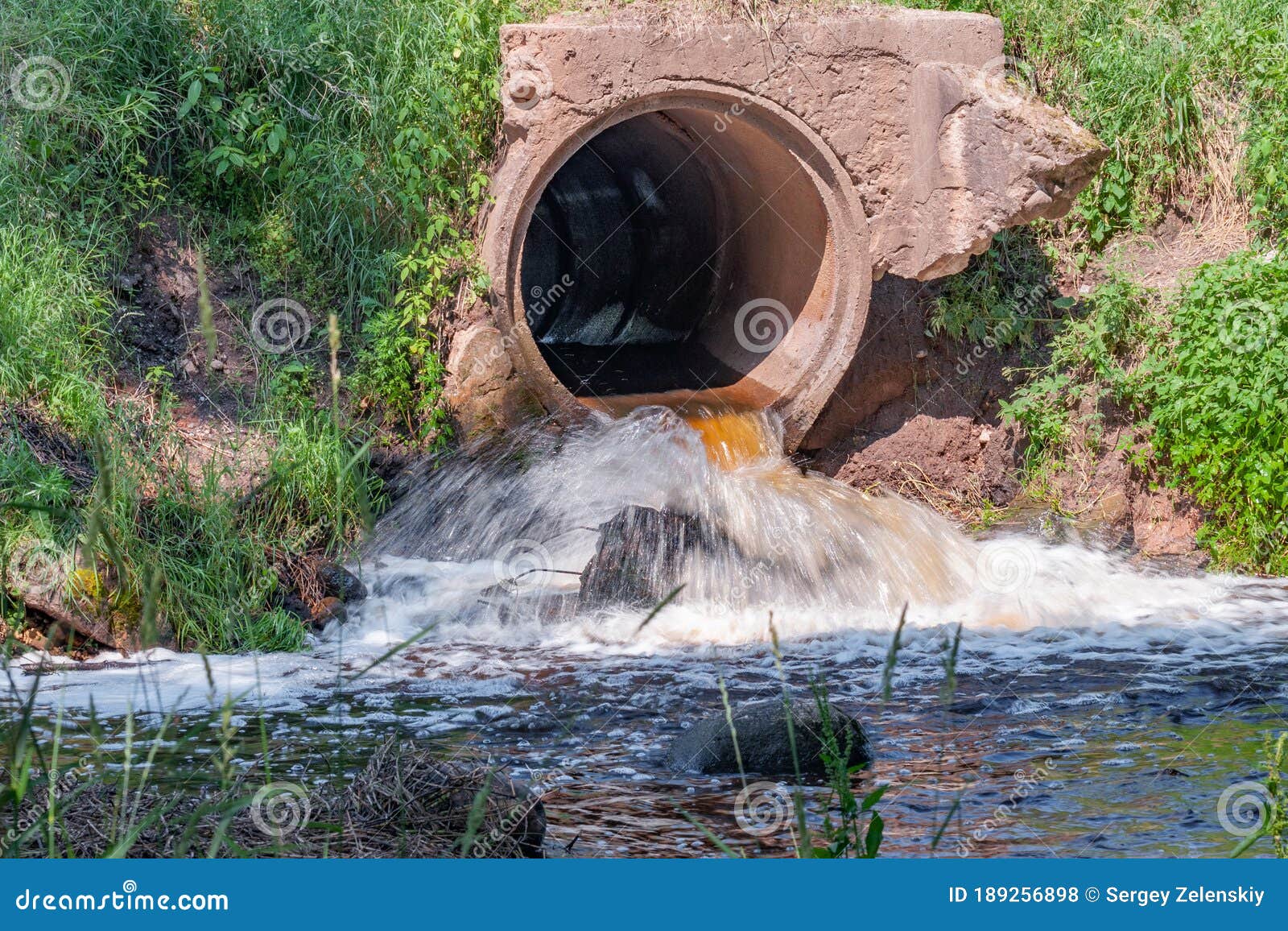 A View of the Stormy Flow of Clear Water from the Culvert on a Bright ...