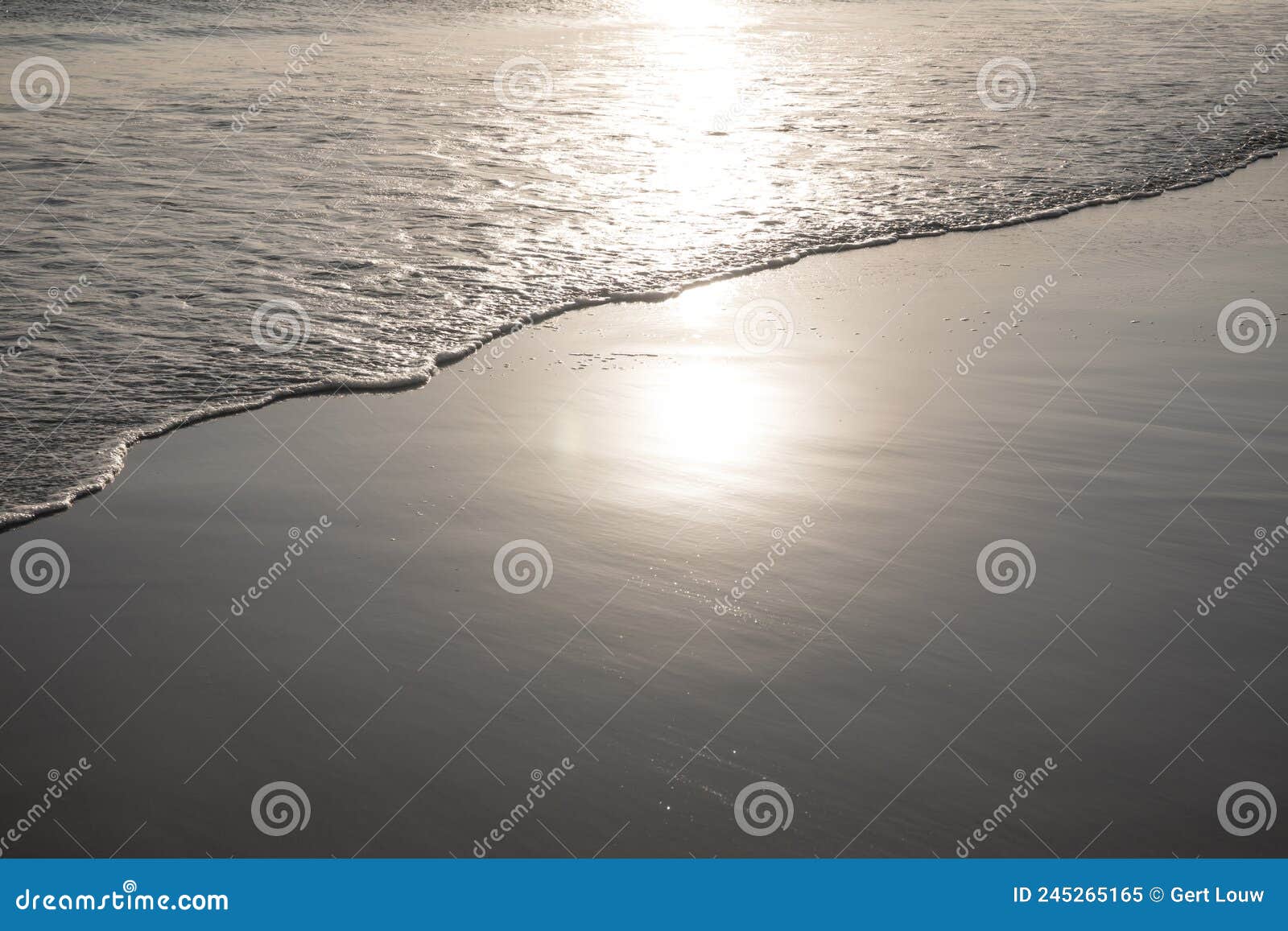 View of Sun Reflecting on Wet Beach Sand with Water Pulling Back Stock ...