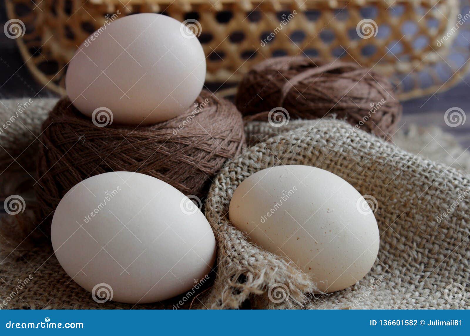 Three Eggs and Brown Threads Lie on a Beige Napkin on a Dark Background ...