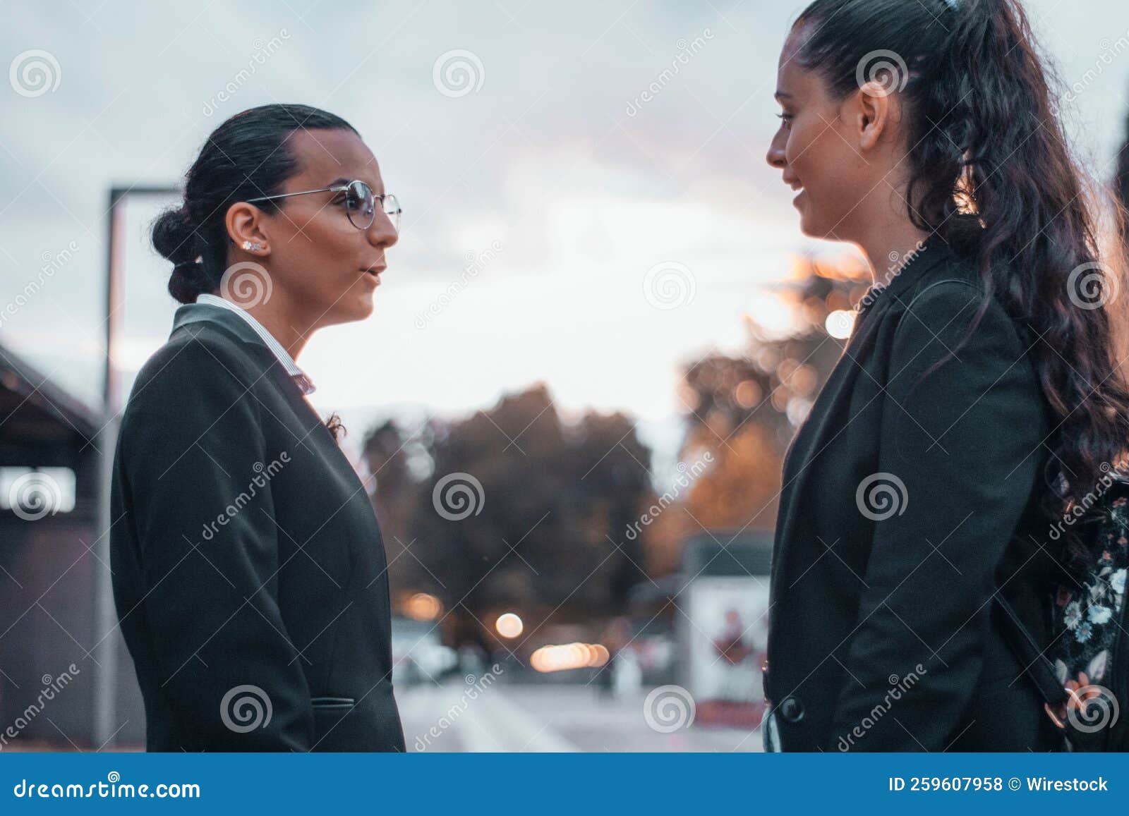 View of Two Female Students Talking while Standing Outdoors Stock Photo ...