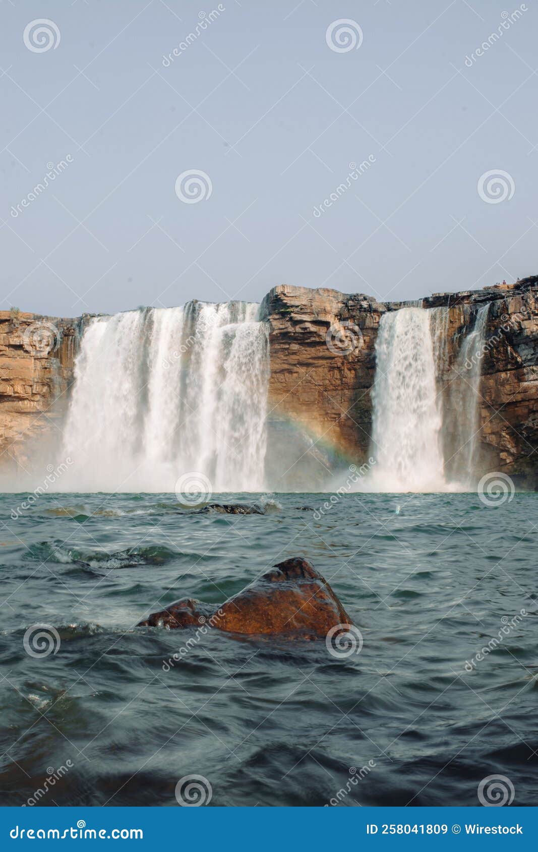 View of Waterfalls Flowing from the Cliff into the Water Under the Blue ...
