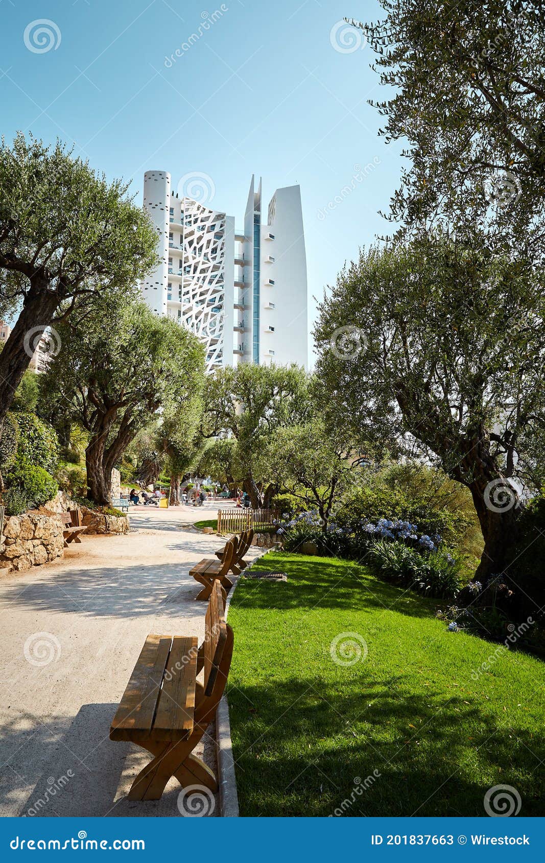 View of Wooden Benches on a Side of the Pathway of a Park with a Modern ...