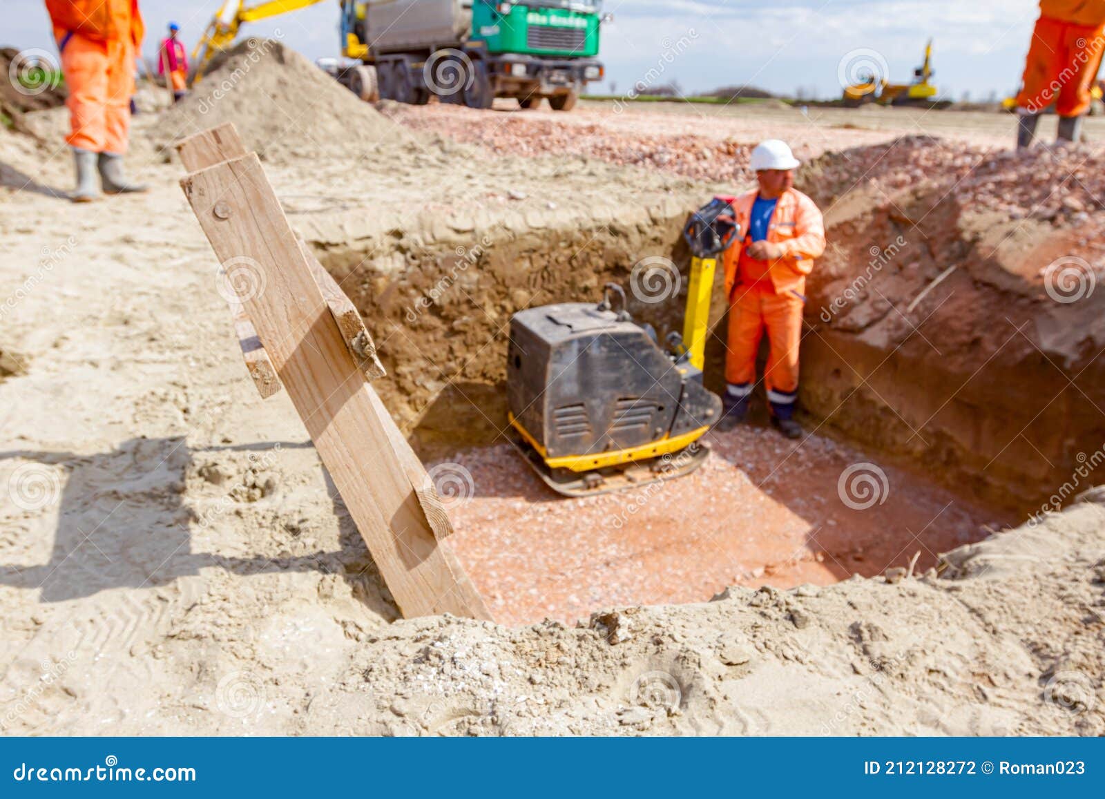 View on Wooden Ladders Placed in Trench, Worker is Compacting ...