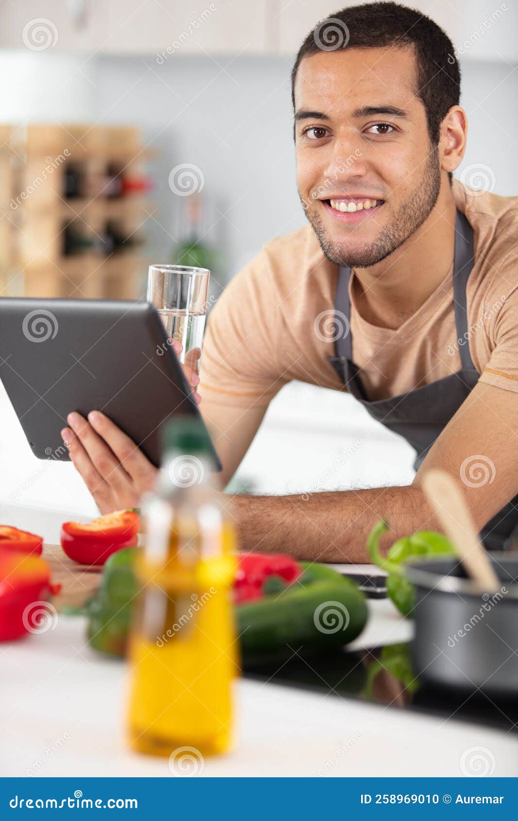 View Young Attractive Man Cooking in Kitchen Stock Photo - Image of ...