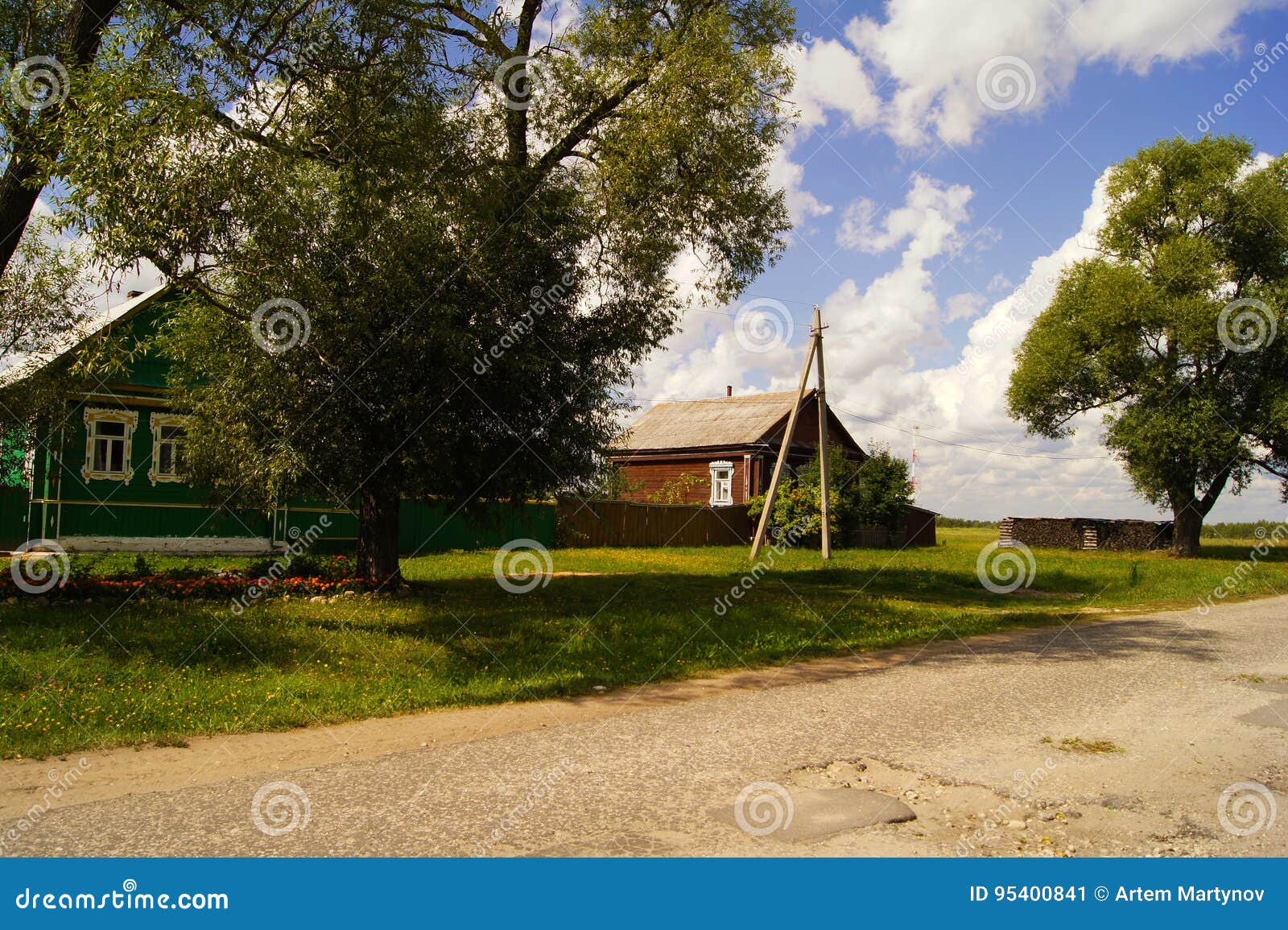 Village Old Wooden Rural Houses With Sloping Roof Beside The Green
