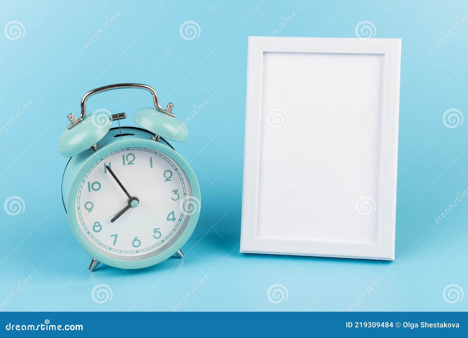 Photo Frame and Blue Alarm Clock on Blue Background with Copy Space ...