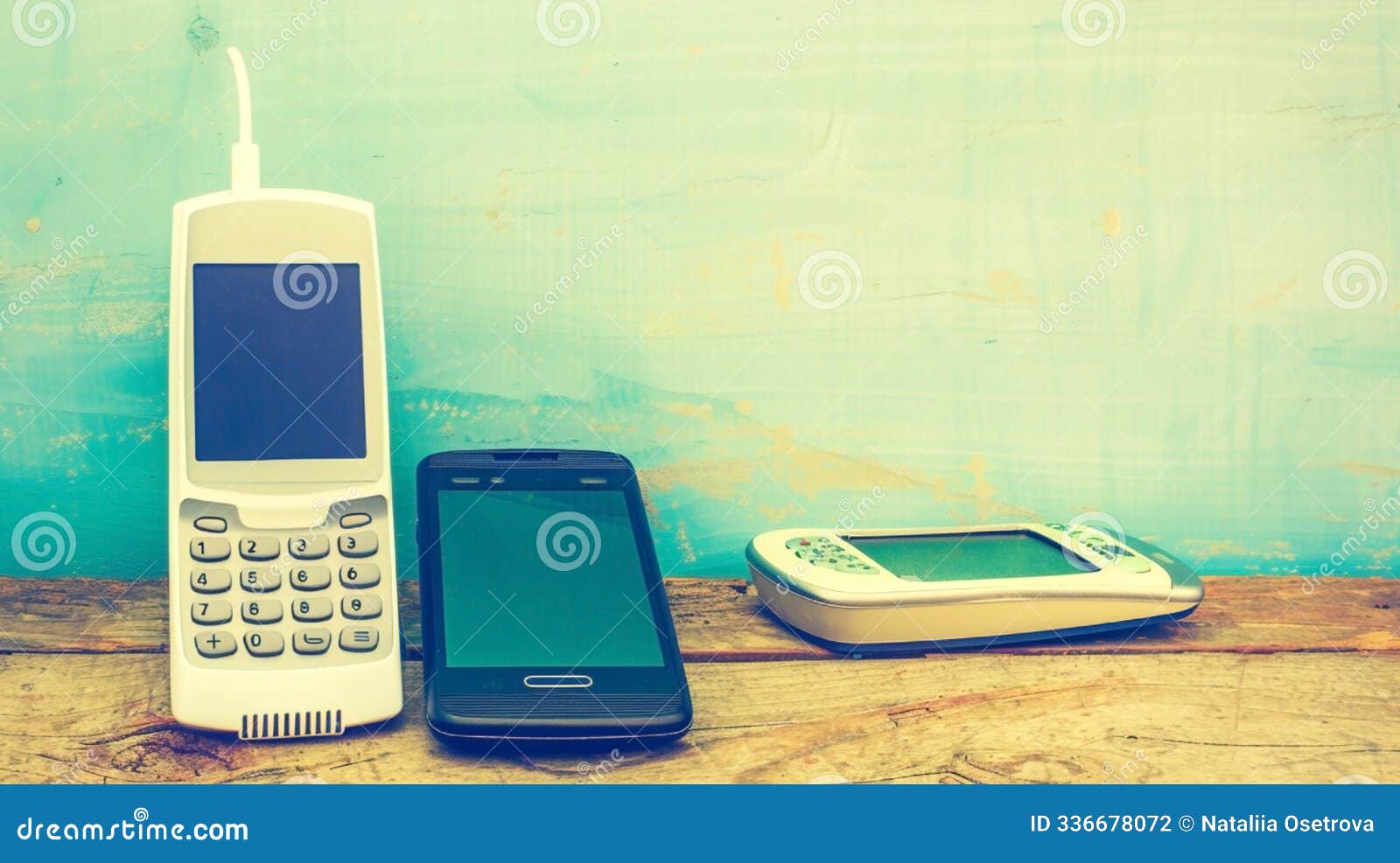 Vintage and Modern Mobile Phones on a Wooden Surface, Representing the ...