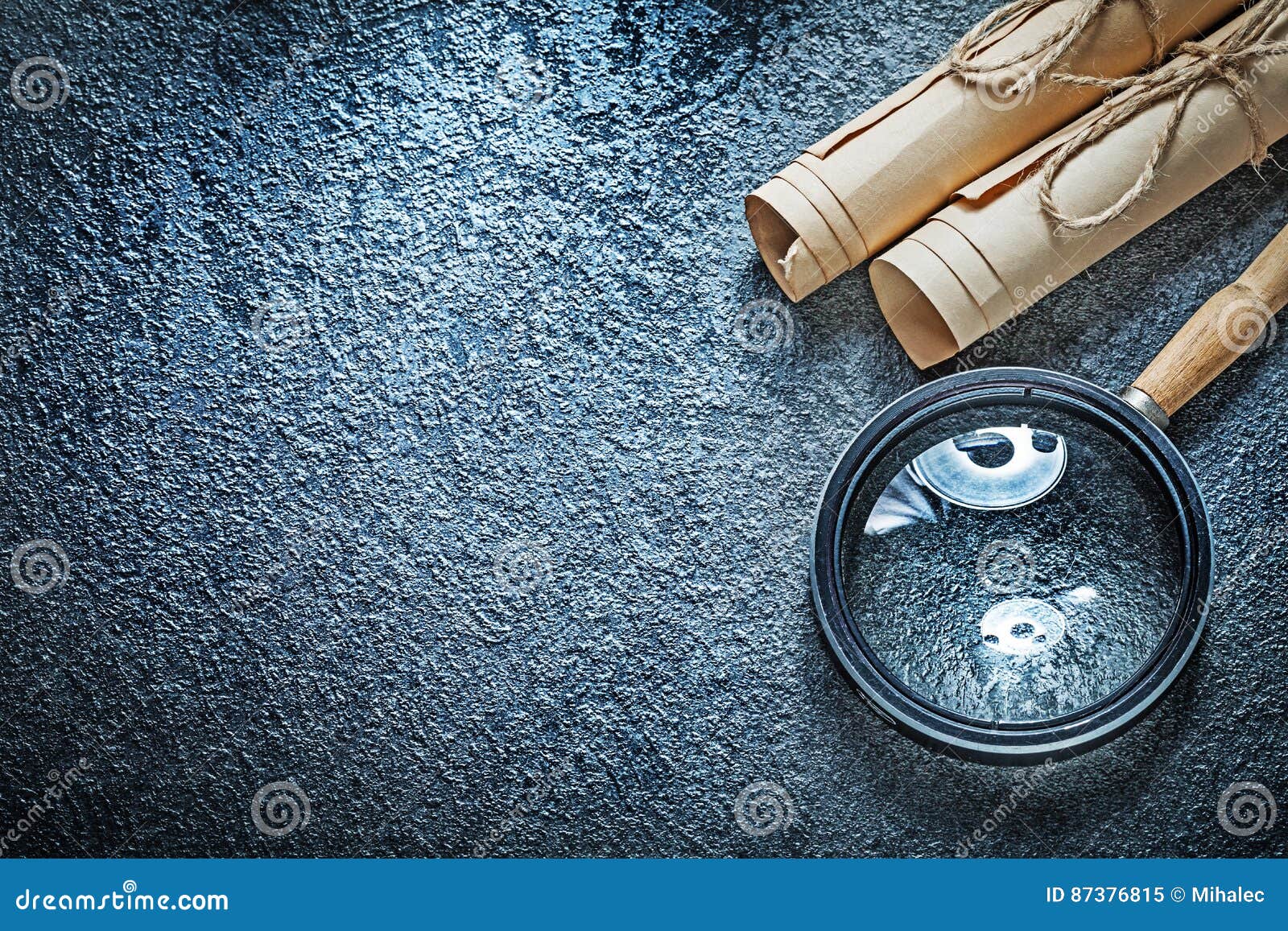 Vintage Paper Rolls Magnifying Glass on Black Surface Stock Image ...