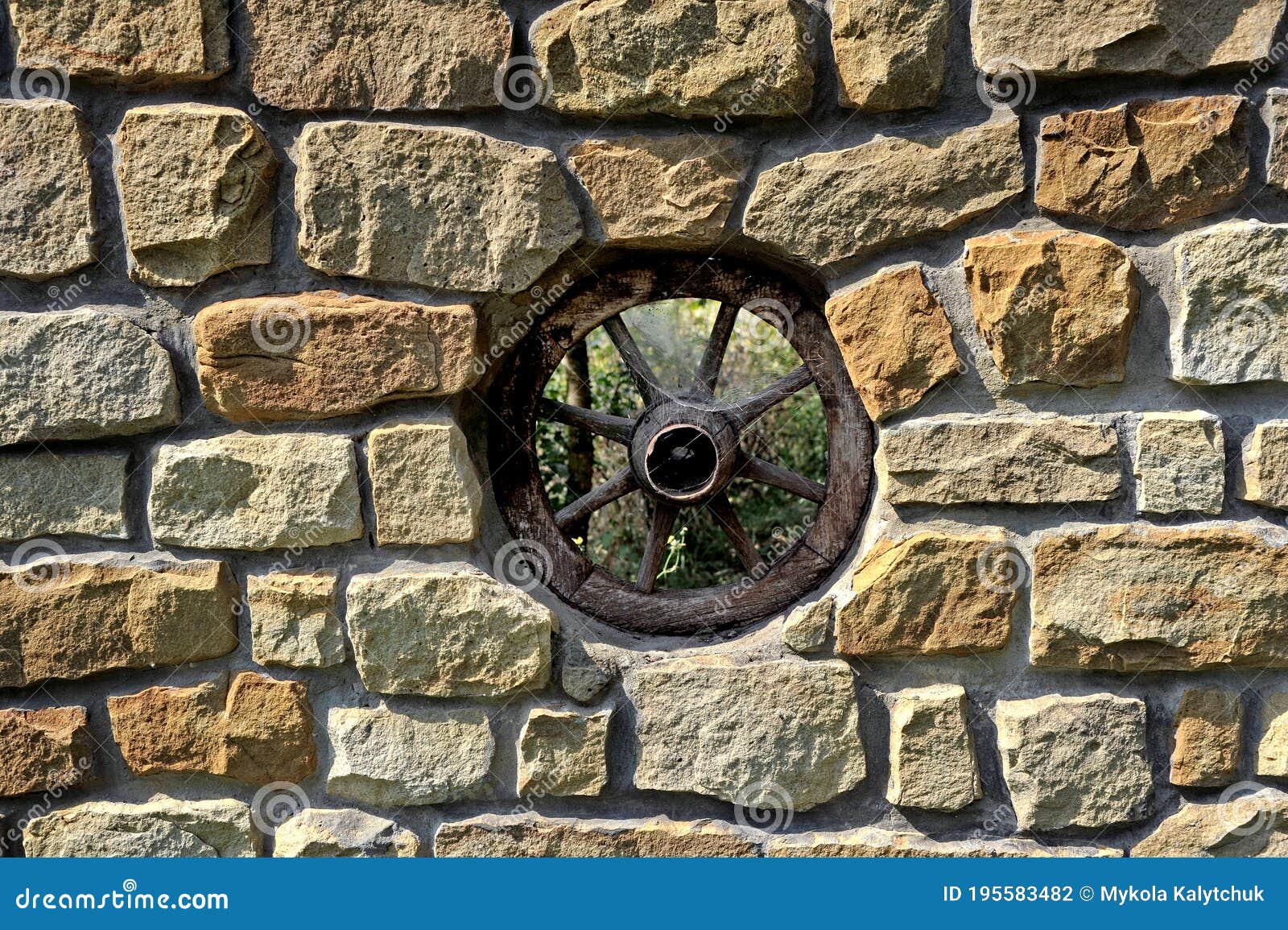 The Vintage Wheel In The Wall Made Of Stones Stock Photo ...