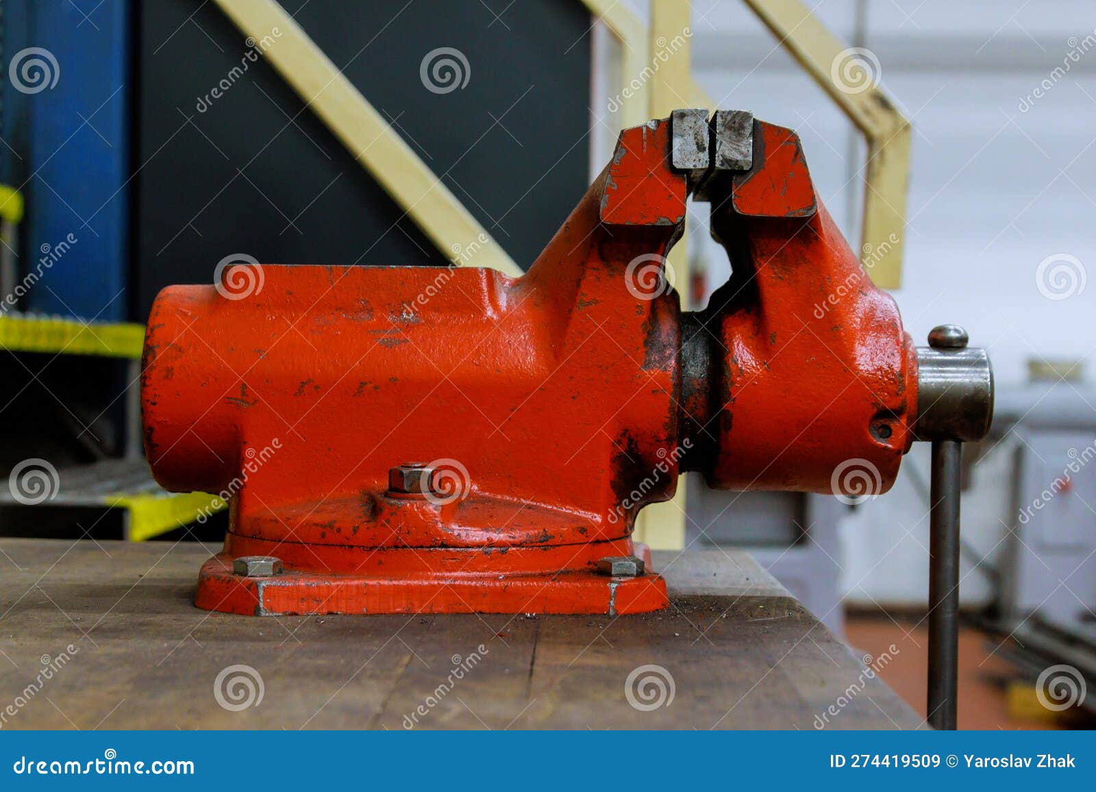 The Vise is Fixed on the Metalworking Workbench. Red Vice on a Wooden ...