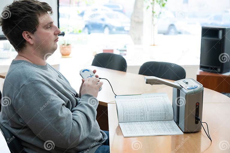 A Visually Impaired Man Uses a Scanning and Reading Machine. Stock ...