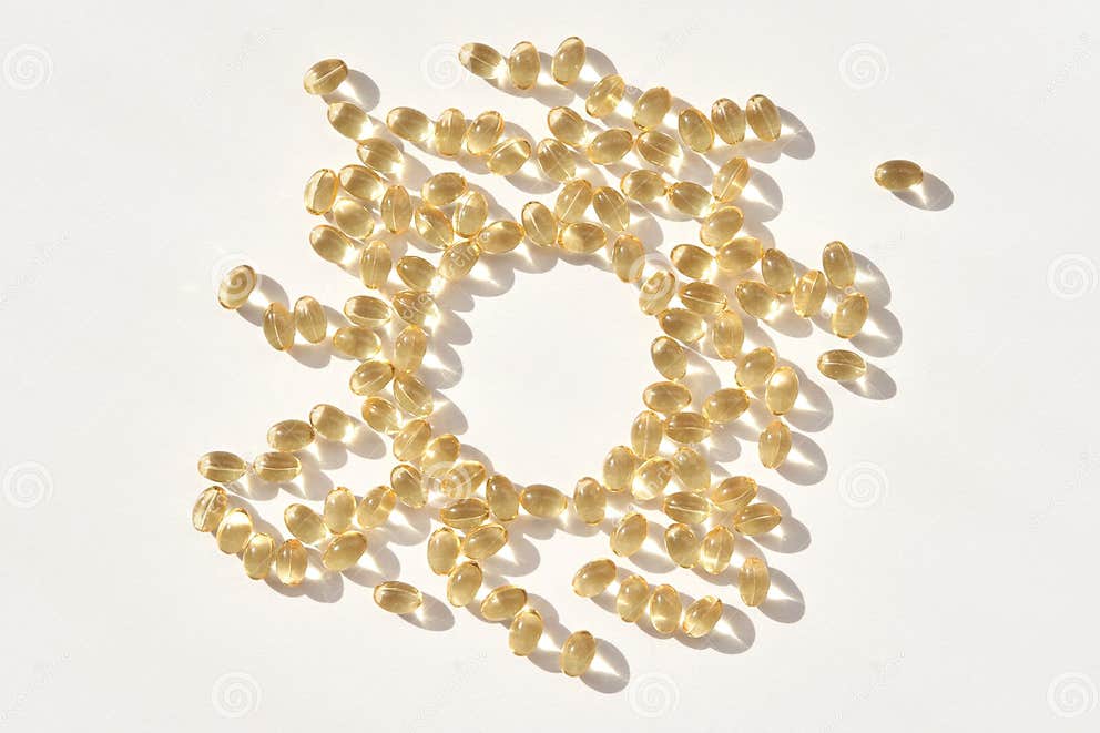 Vitamin D Capsules Arranged in Circle on White Surface with Shadows and ...