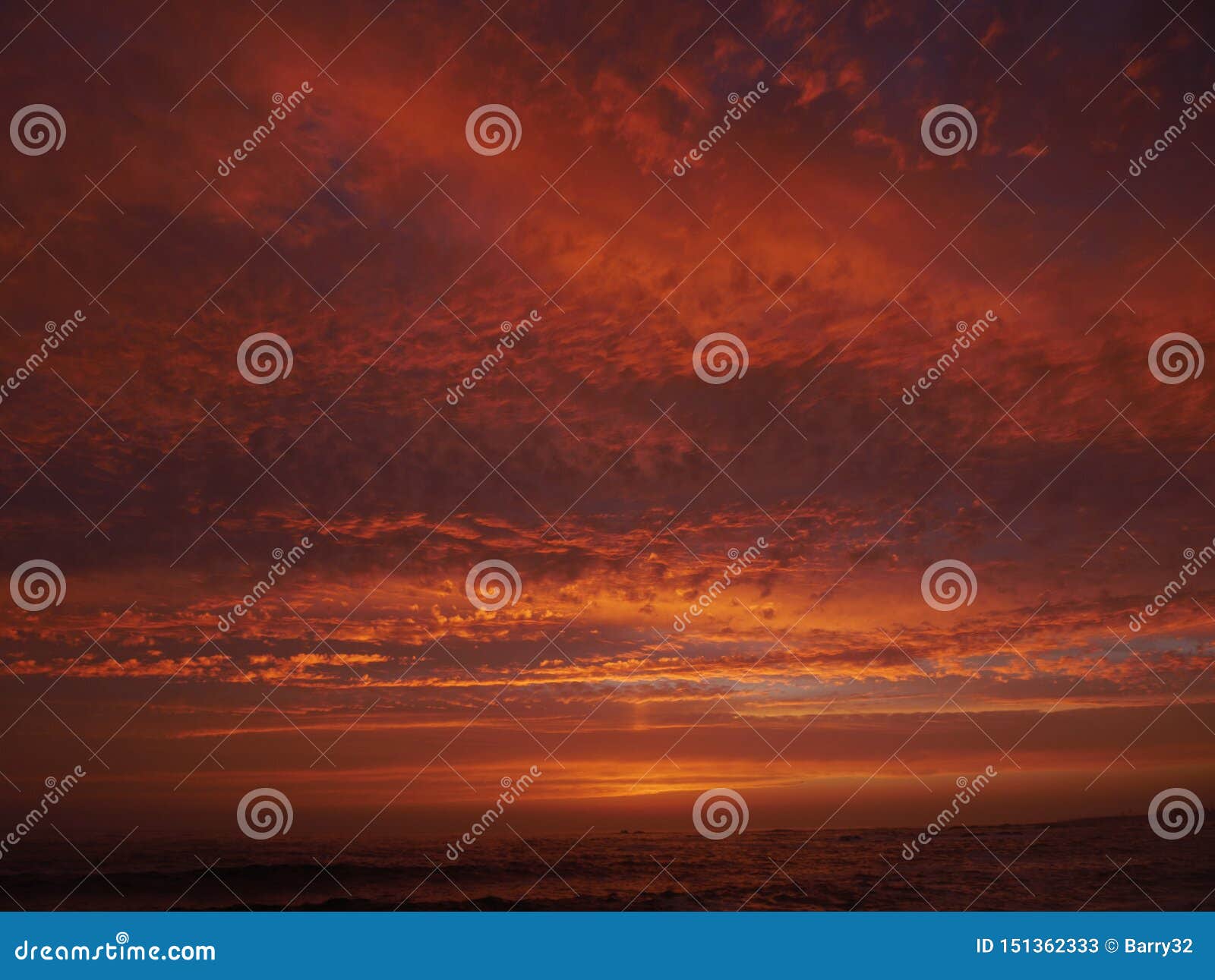 Vivid Red Sky at Sunset on Beach with Dramatic Clouds and Dark Sea ...