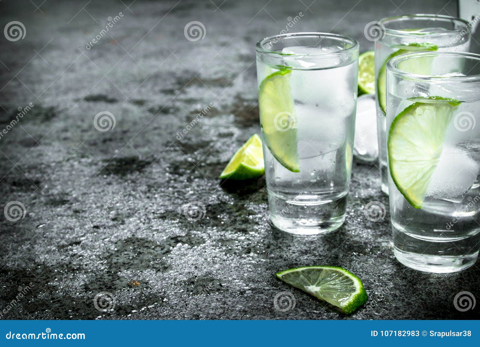 Vodka with Pieces of Lime and Ice Cubes. Stock Image - Image of black ...