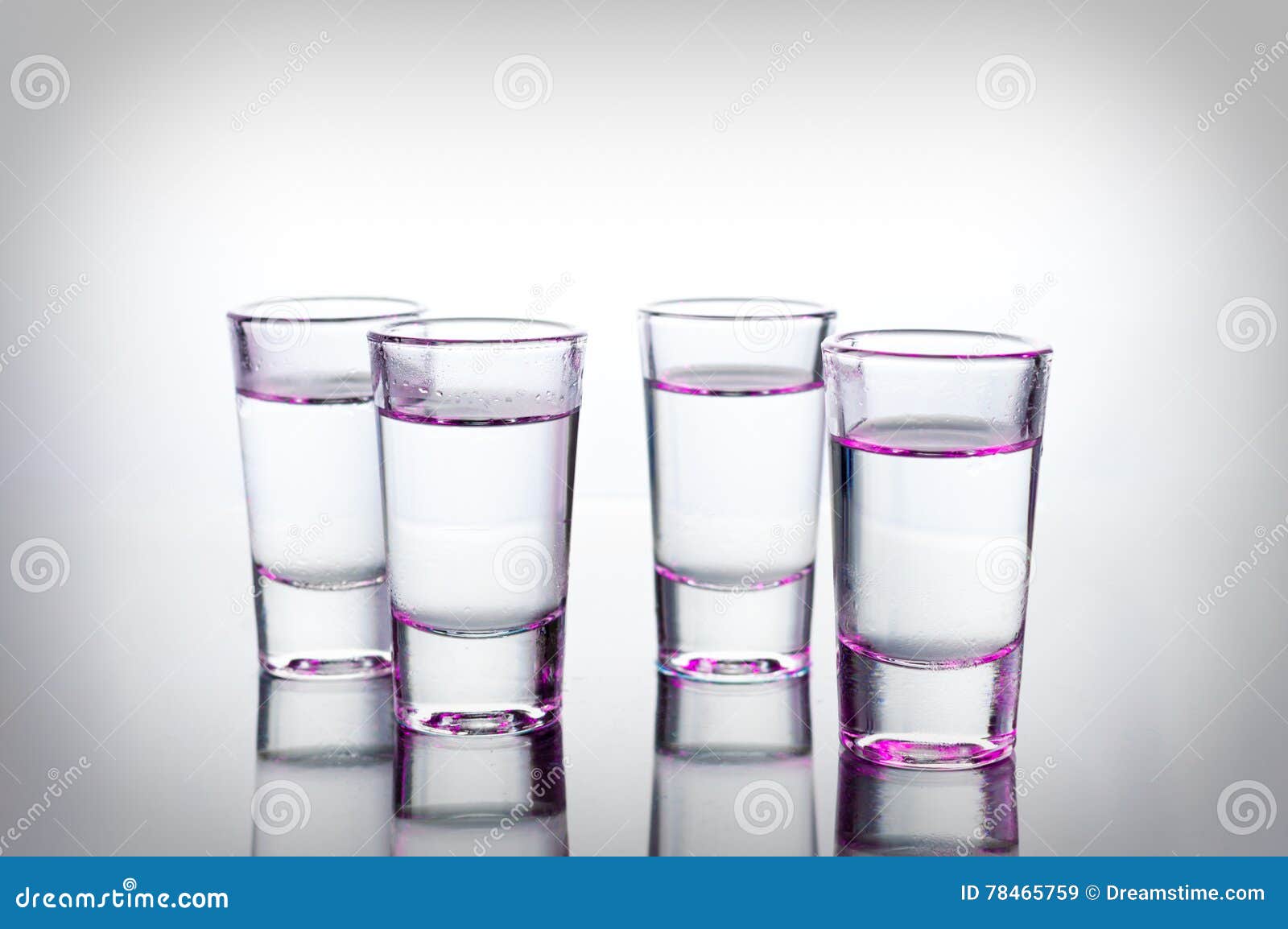 Vodka Shots Lighted with Pink Light Filled with Alcohol on Glass Bar ...