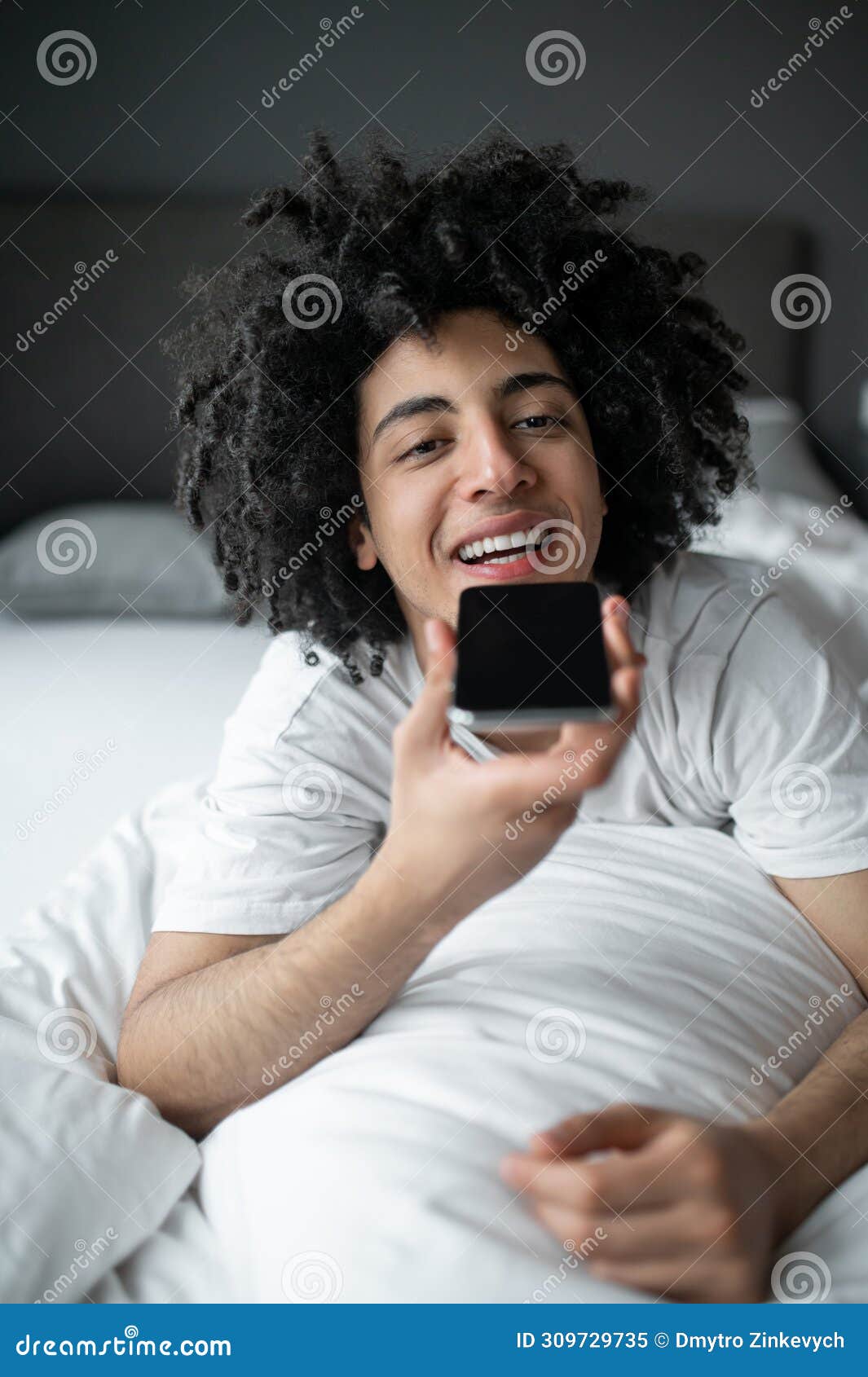 Young Man Lying in Bed and Recording a Voice Message Stock Image ...