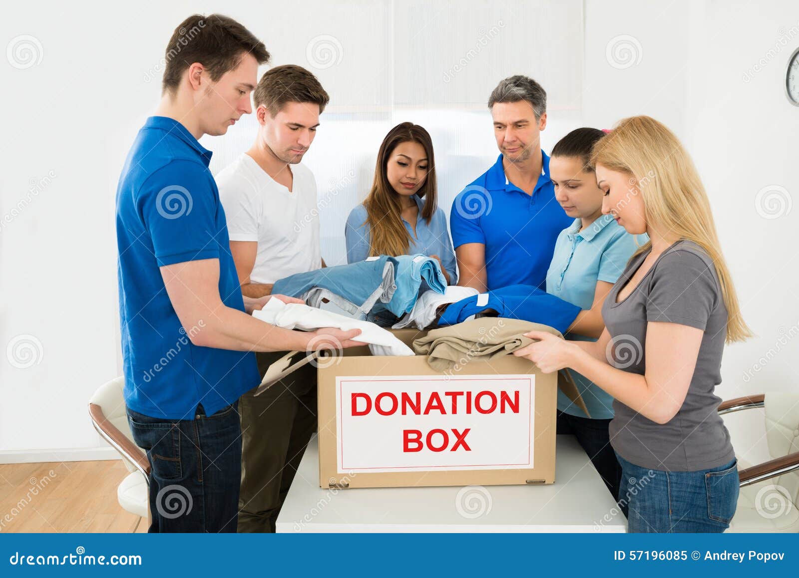 Voluntarios Que Sostienen La Ropa Para Donar Imagen de archivo - Imagen ...