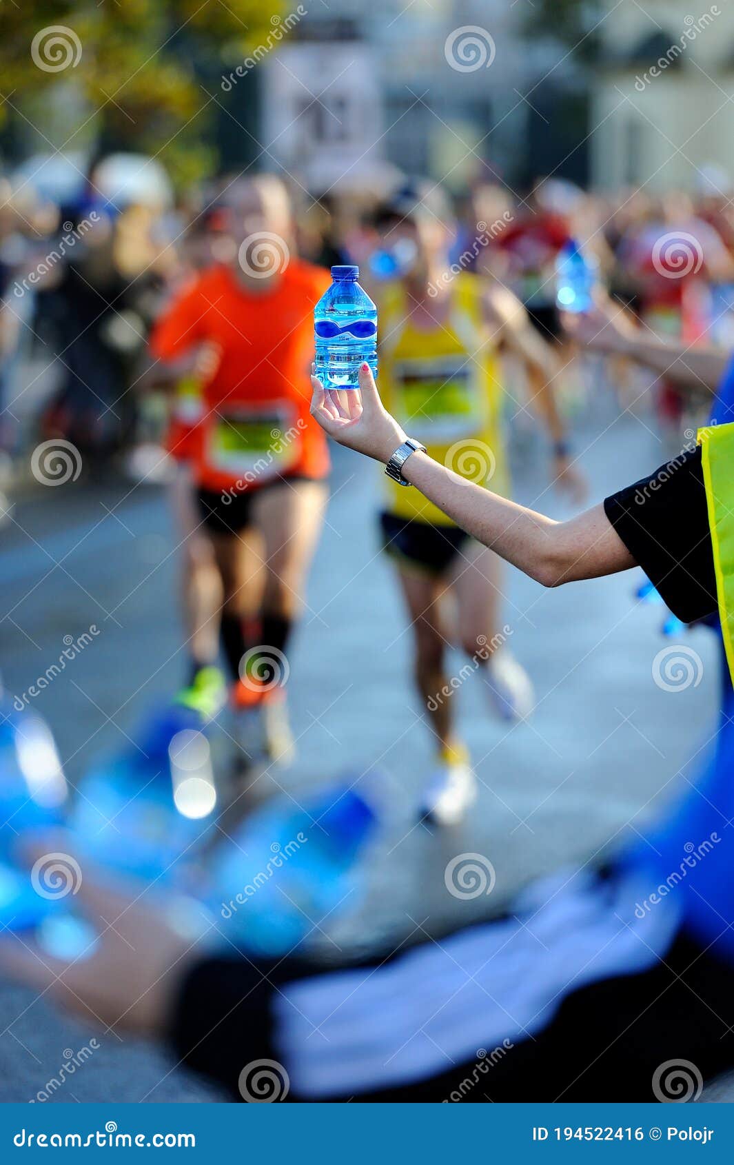 Volunteer Hand Offering a Small Bottle of Water at a Marathon ...