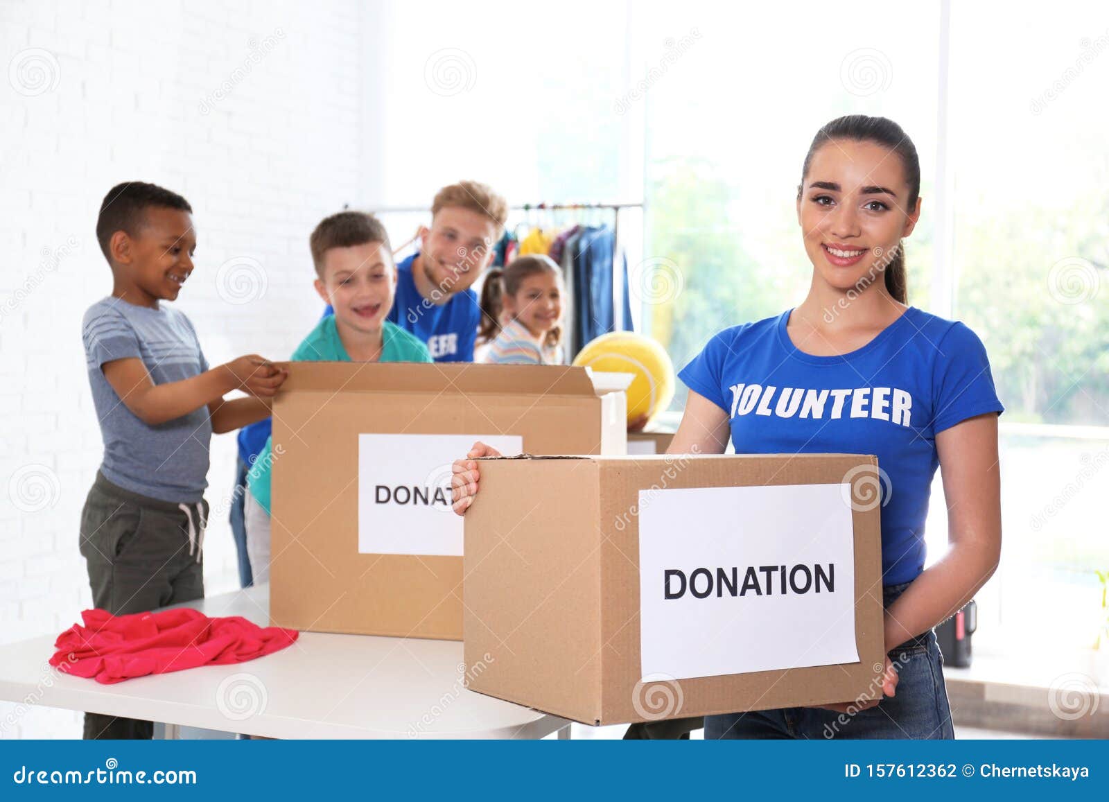 Volunteers with Children Sorting Donation Goods Stock Photo - Image of ...