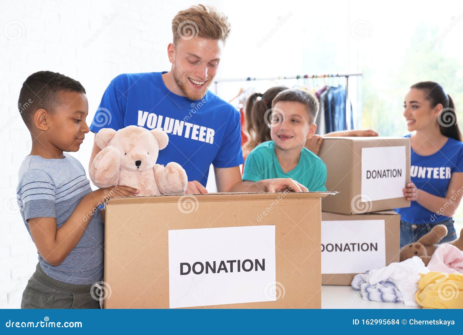 Volunteers with Children Sorting Donation Goods Stock Photo - Image of ...