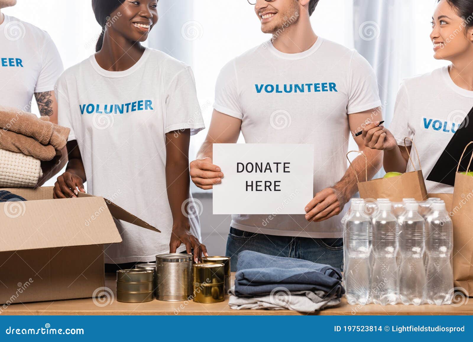 Volunteers Holding Card with Donate Here Stock Photo - Image of ...