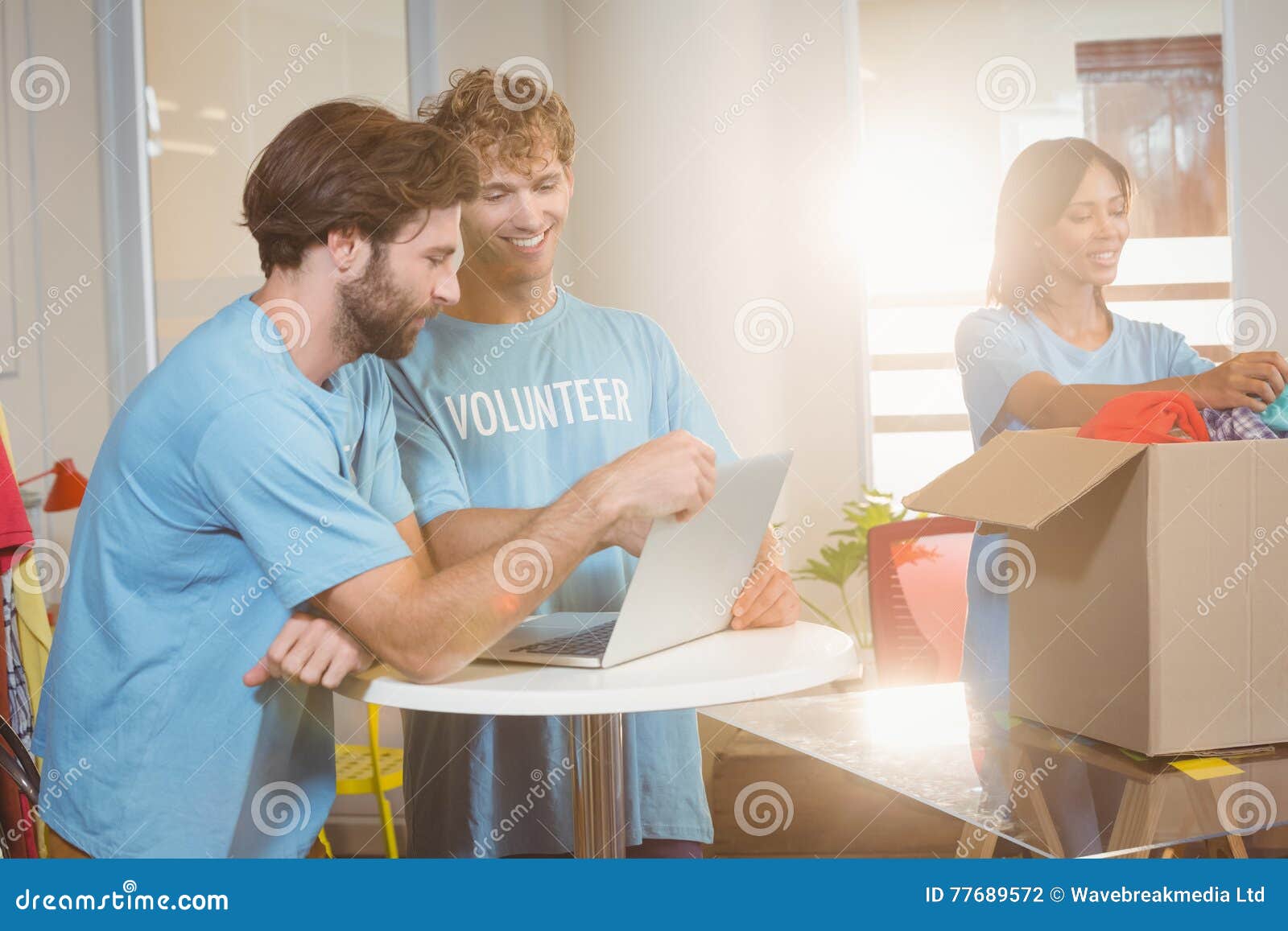Volunteers using a laptop stock photo. Image of participate - 77689572