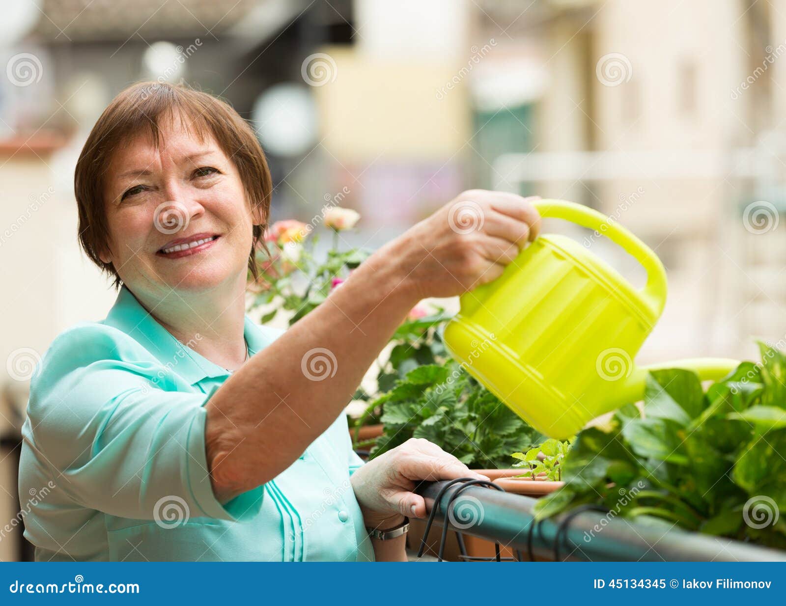Vrouw Het Water Geven Installaties Op Balkon Stock Afbeelding - Image ...